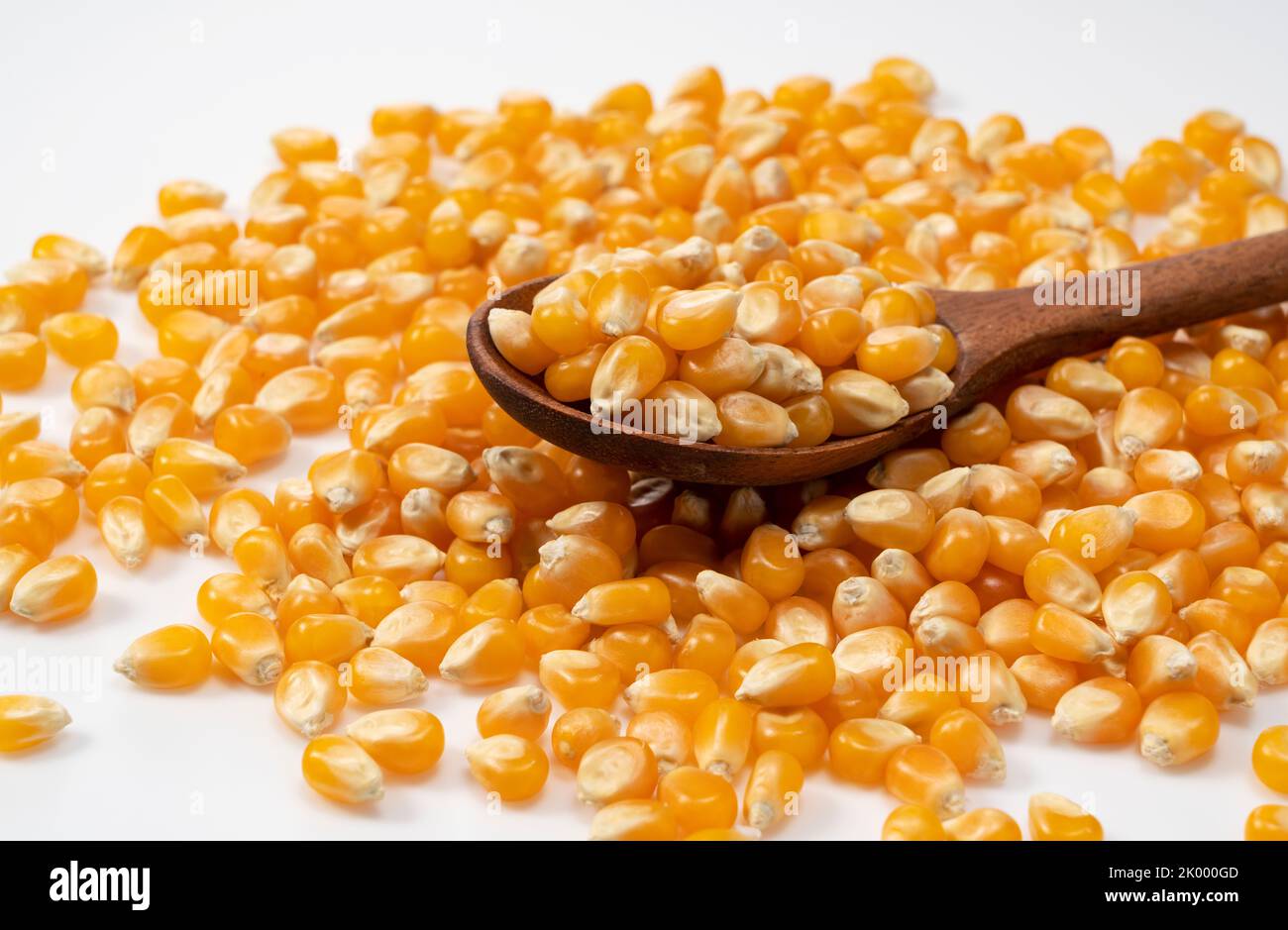 Dried corn kernels and wooden spoon placed on white background. Corn ...