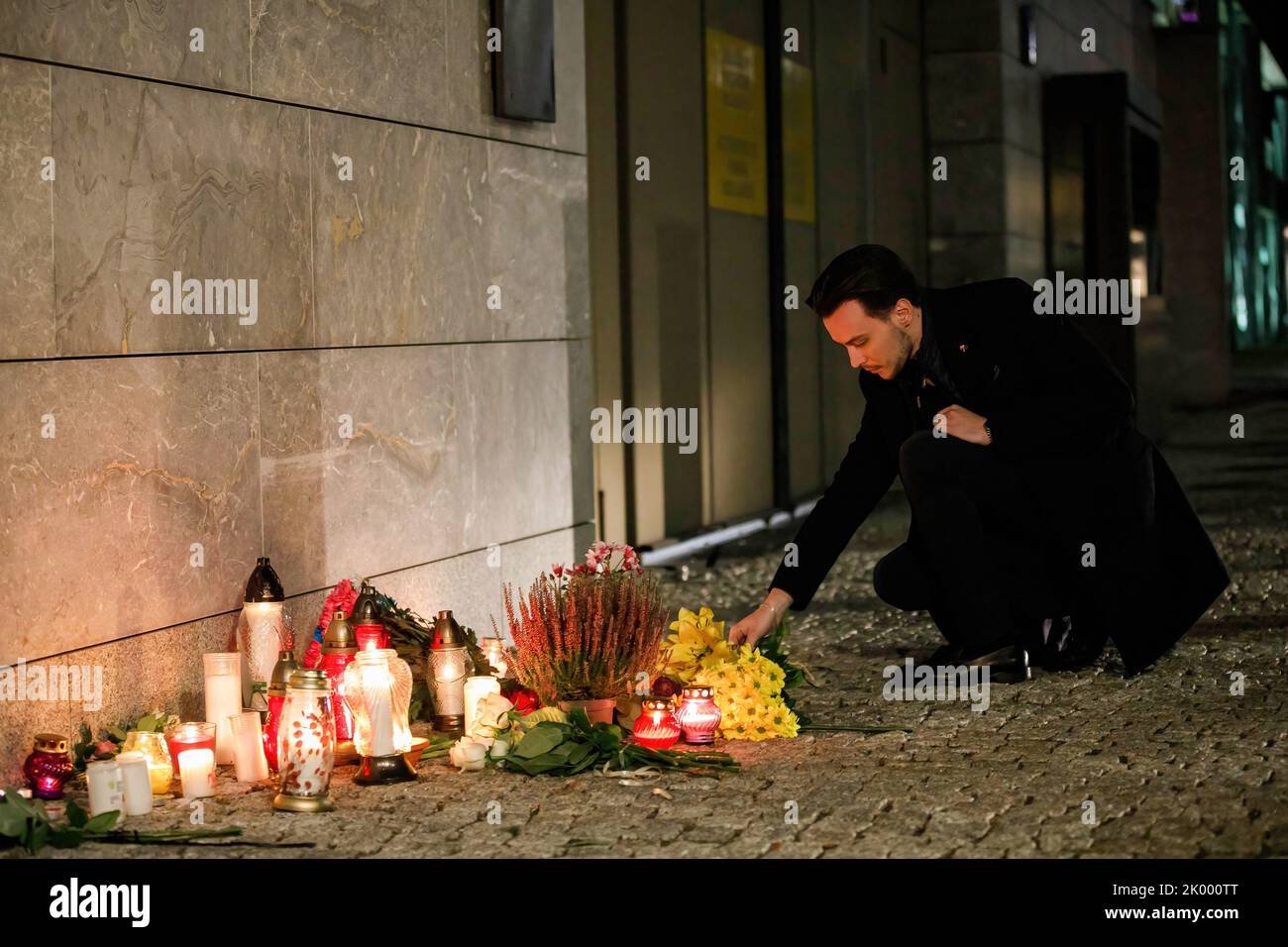 A man lays flowers down near the fence of the British Embassy in Warsaw ...