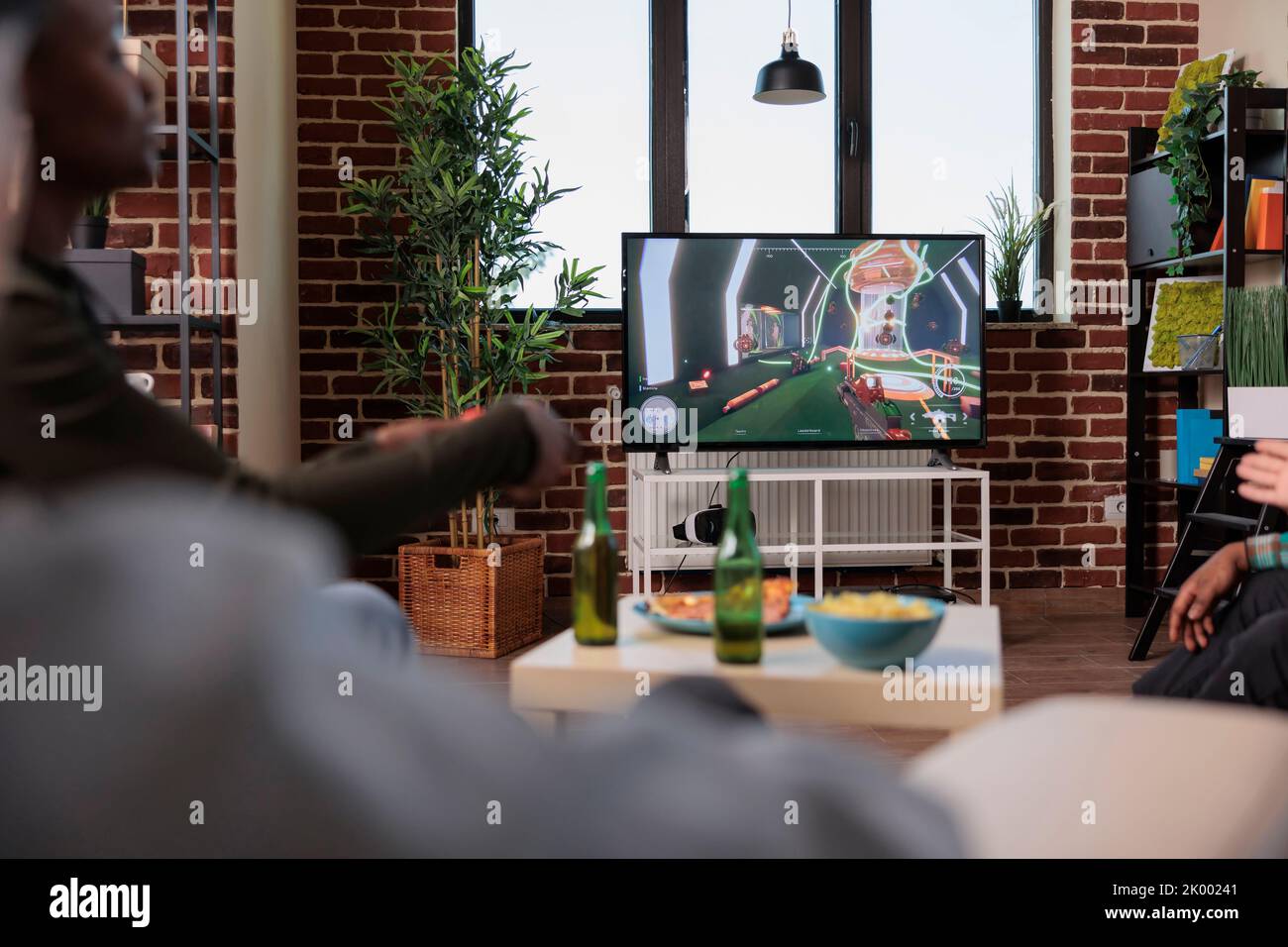Modern people having fun playing shooting video games, using tv console ...