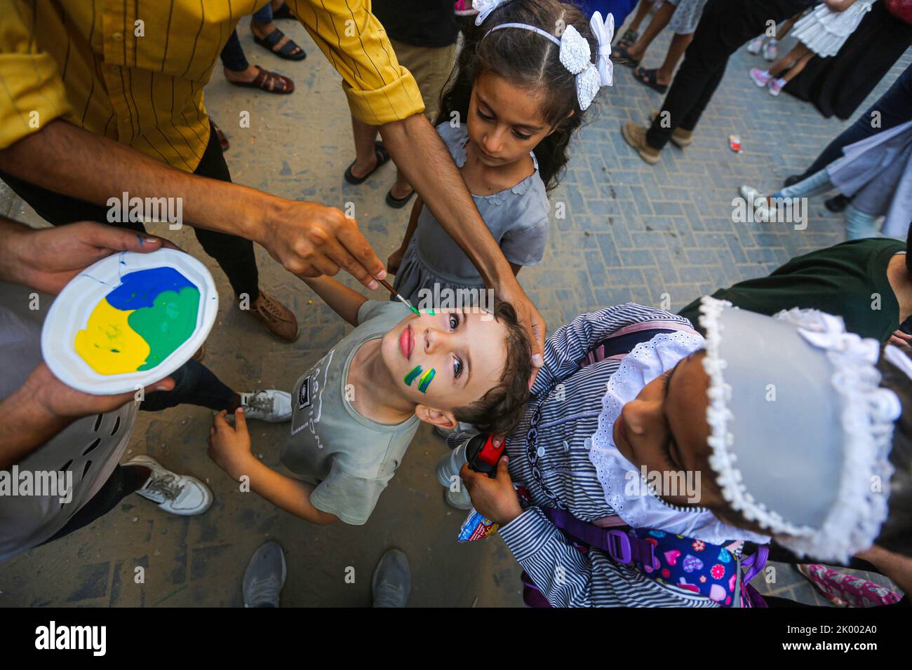 Gaza, 08/09/2022, A Palestinian artist paints a child's face during the ...