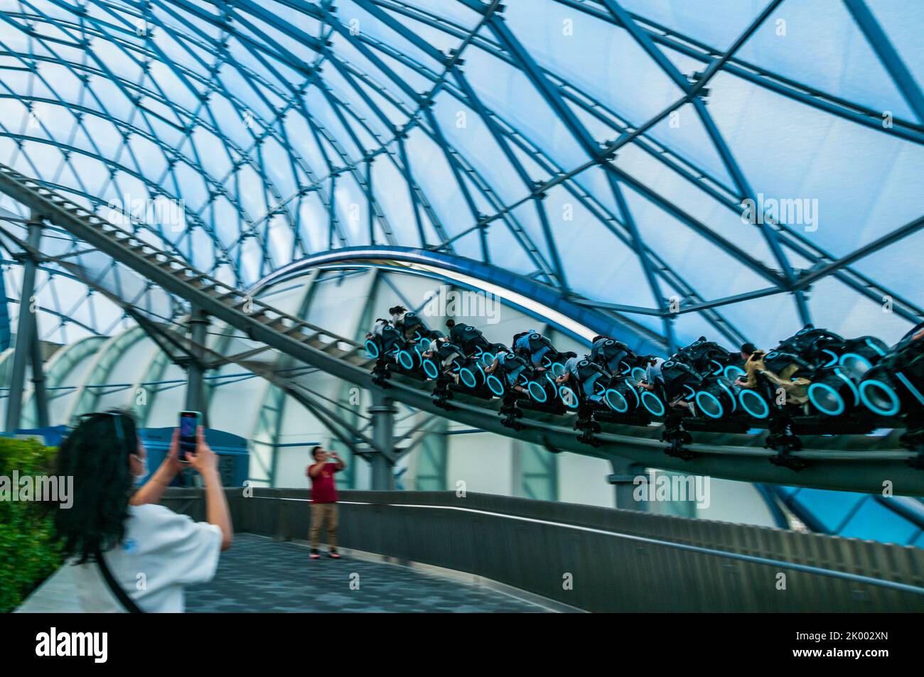 People taking smartphone pictures of the Tron Lightcycle Power Run ride ...