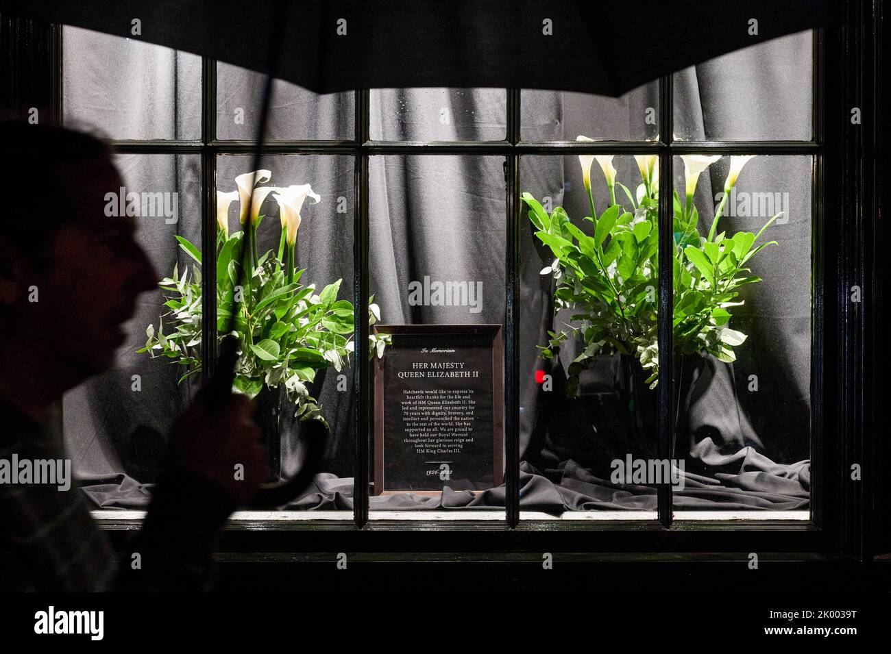 A person walks by the memorial display window of Queen Elizabeth II at ...