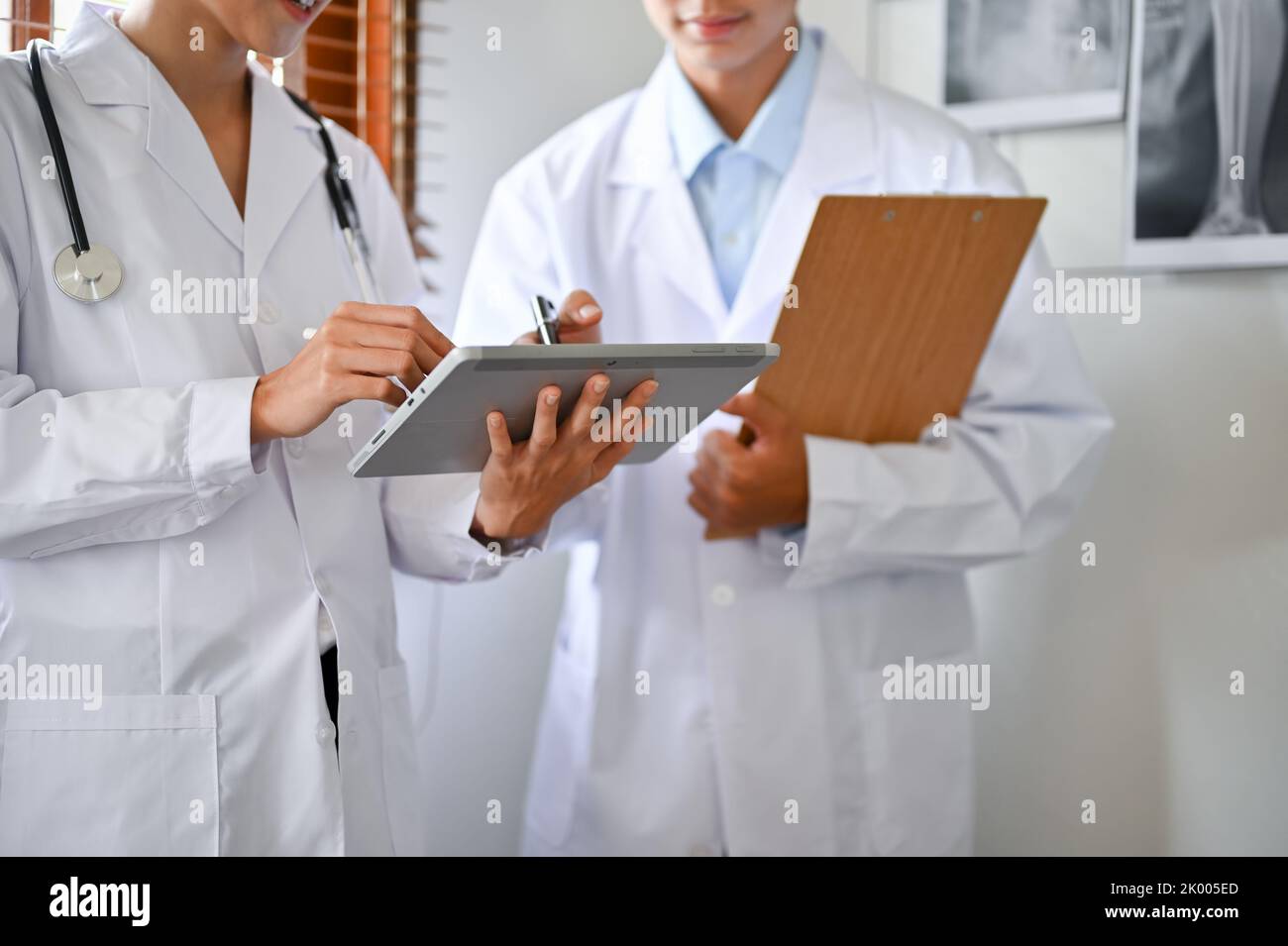 Two expert young Asian female and male doctor in a white coat are ...