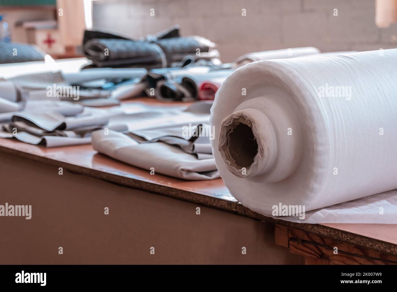 Fabric of different types and sintepon in a sewing workshop Stock Photo ...