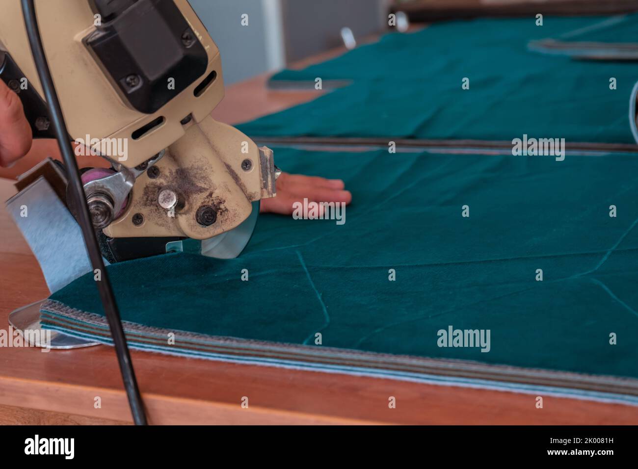 The cutter cuts the fabric with a disc knife in a sewing workshop Stock ...