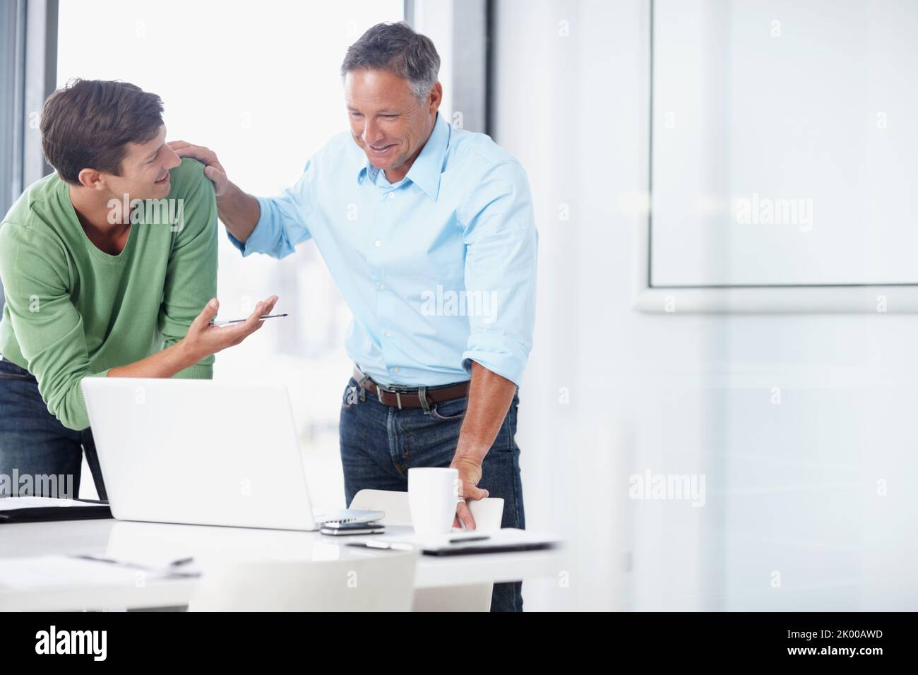 He is proud of his protege. A mature advertising executive working with ...