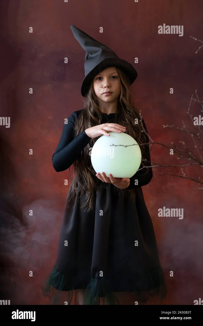 The witch with magic ball in her hands causes a spirits in cave. High ...