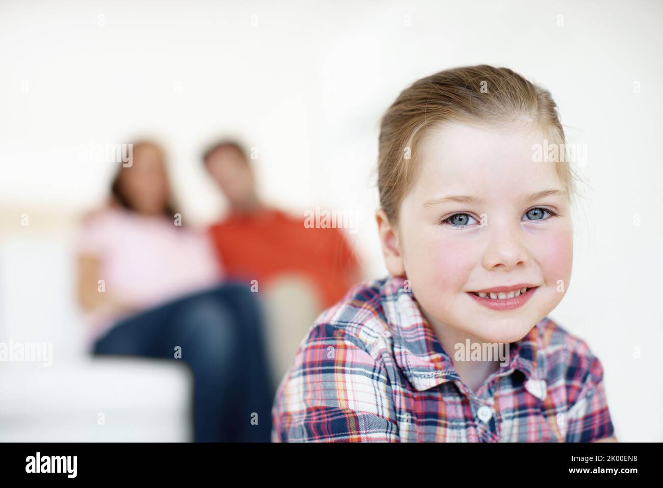 Her parents watch over her. A young girl poses with her parents in the ...