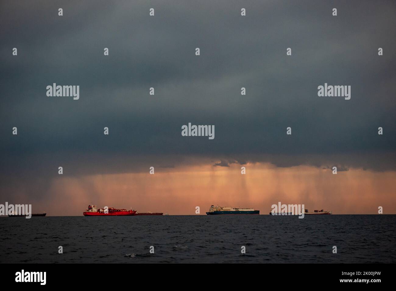 Rain falls on cargo ships off the coast in Barcelona Stock Photo - Alamy