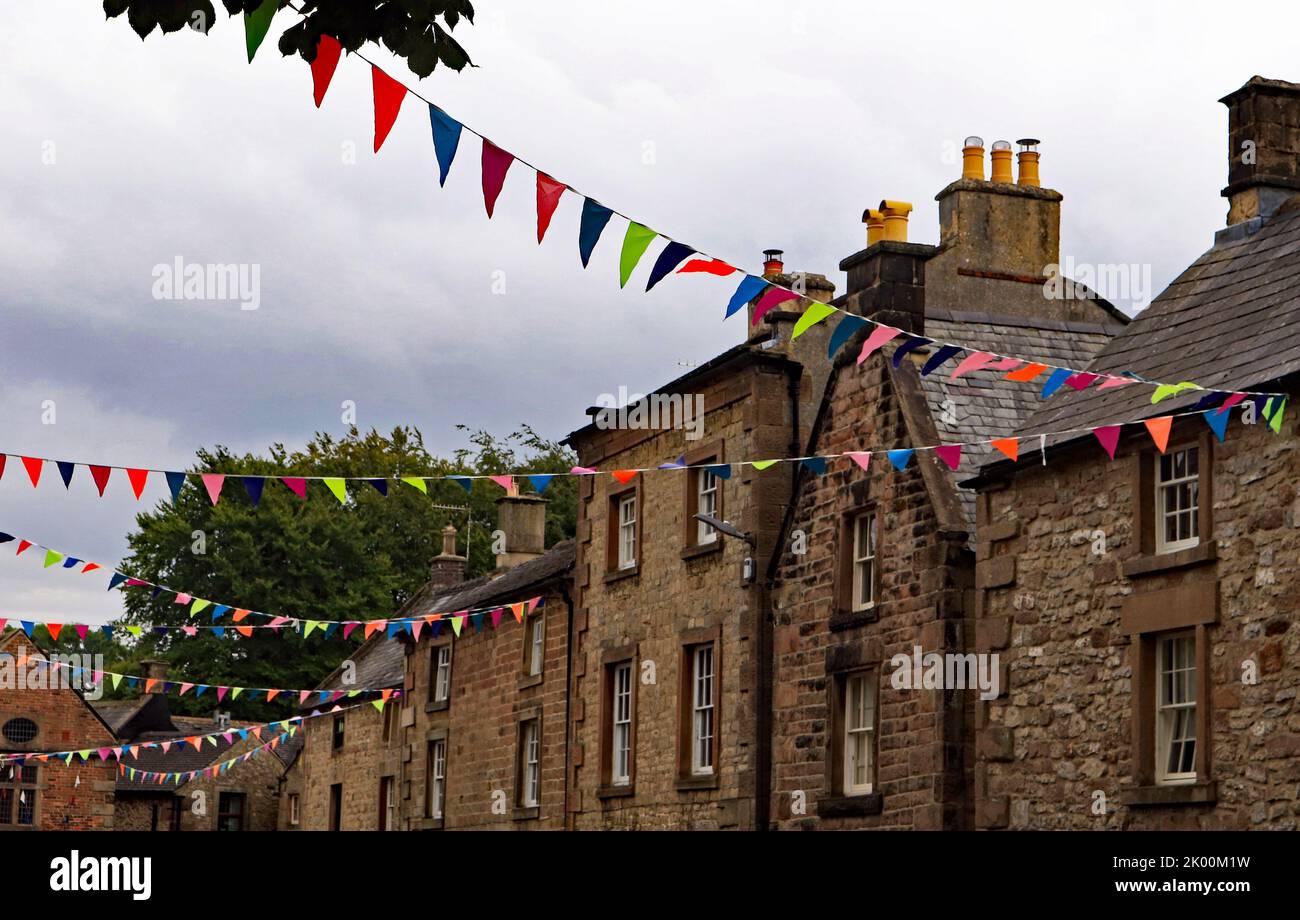 Colourful bunting strung out between the cottages on the Main Street of ...