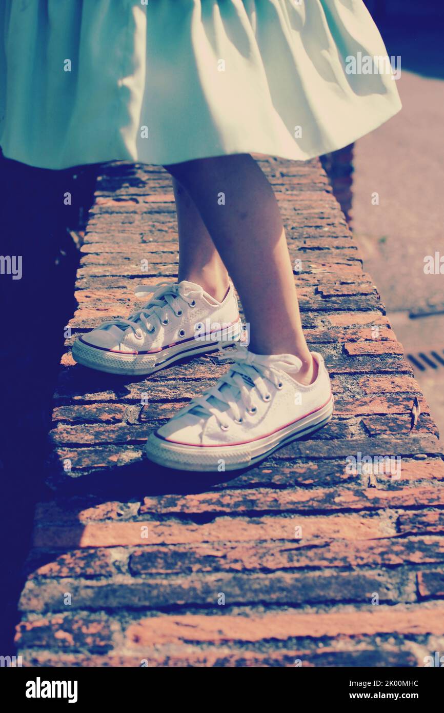 Shot of a kid with white shoes on bricks Stock Photo - Alamy