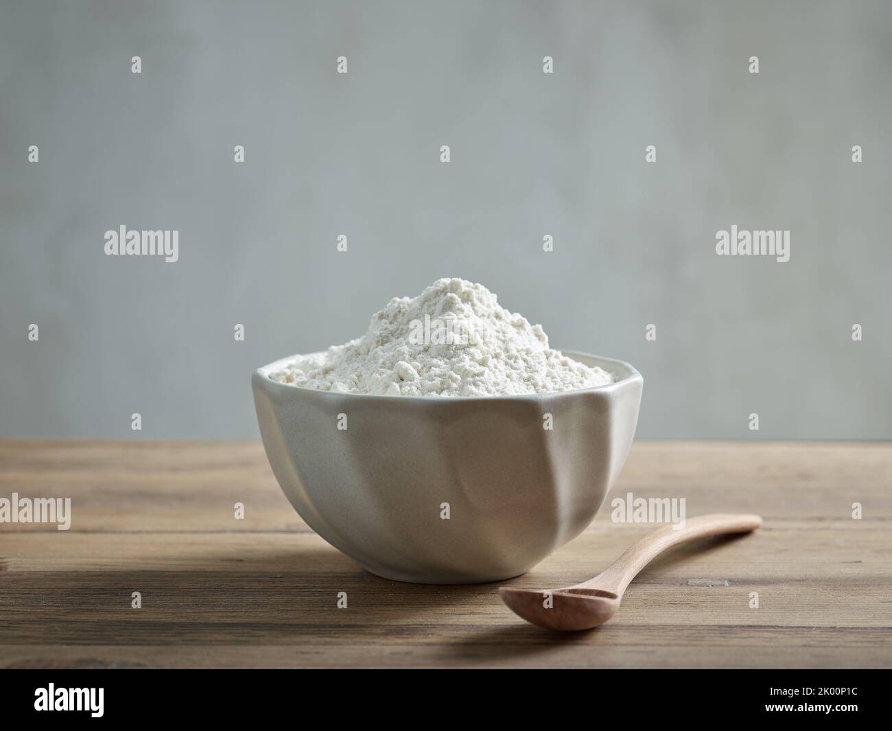 ceramic bowl of flour and spoon on wooden kitchen table Stock Photo - Alamy