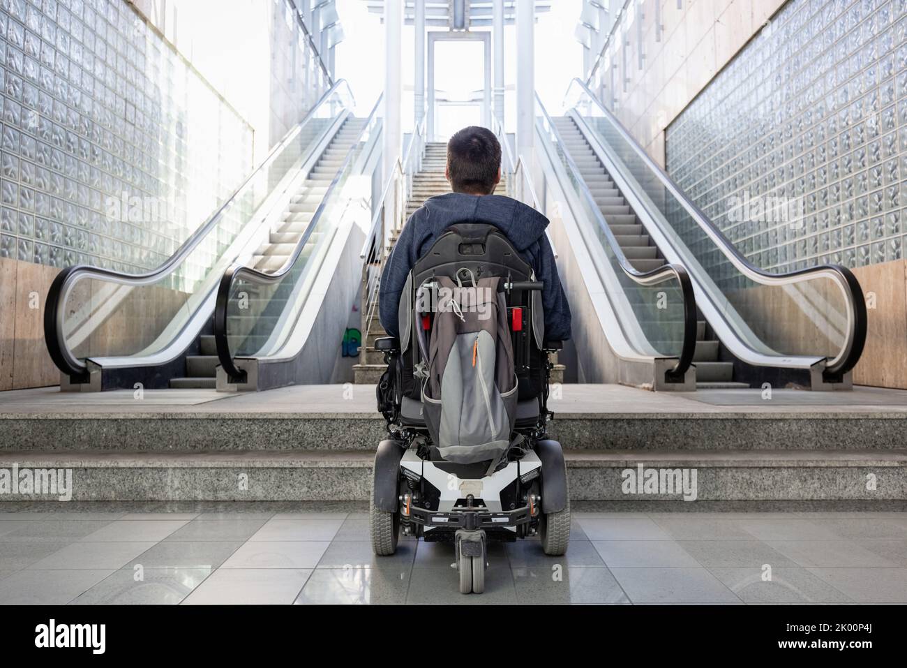 Person with disability on electric wheelchair stopping at the bottom of ...
