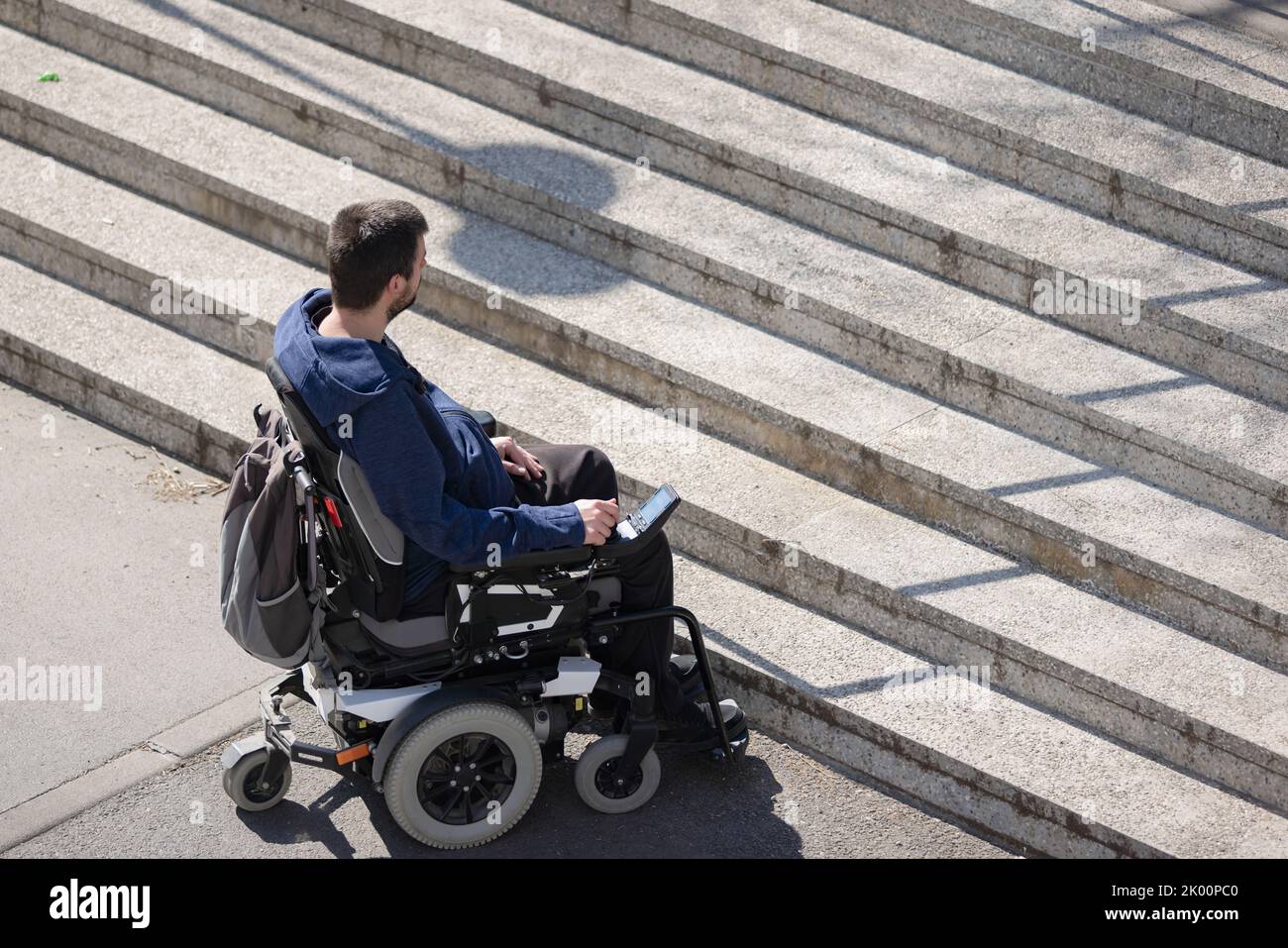 Person with disability on electric wheelchair stopping at the bottom of ...