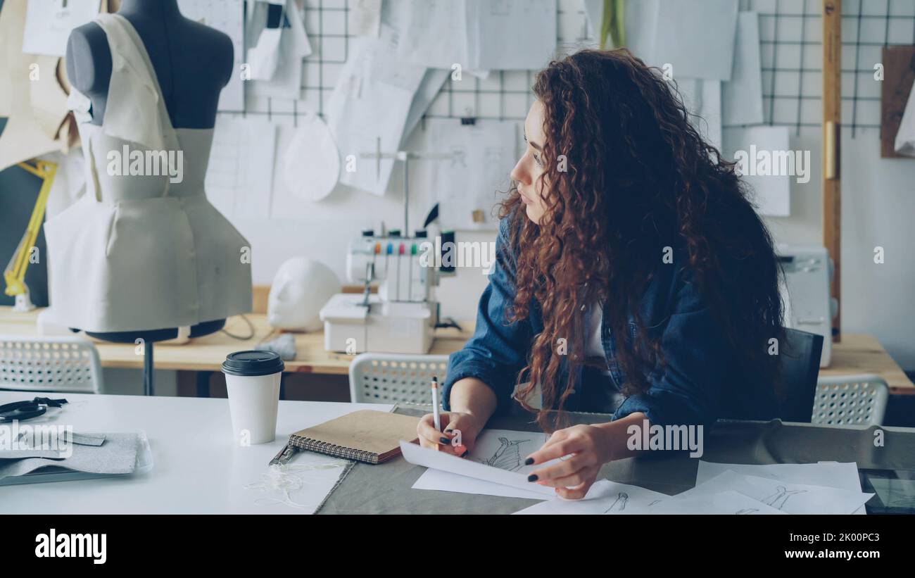 Young female artist fashion designer is drawing women's garment sketch ...