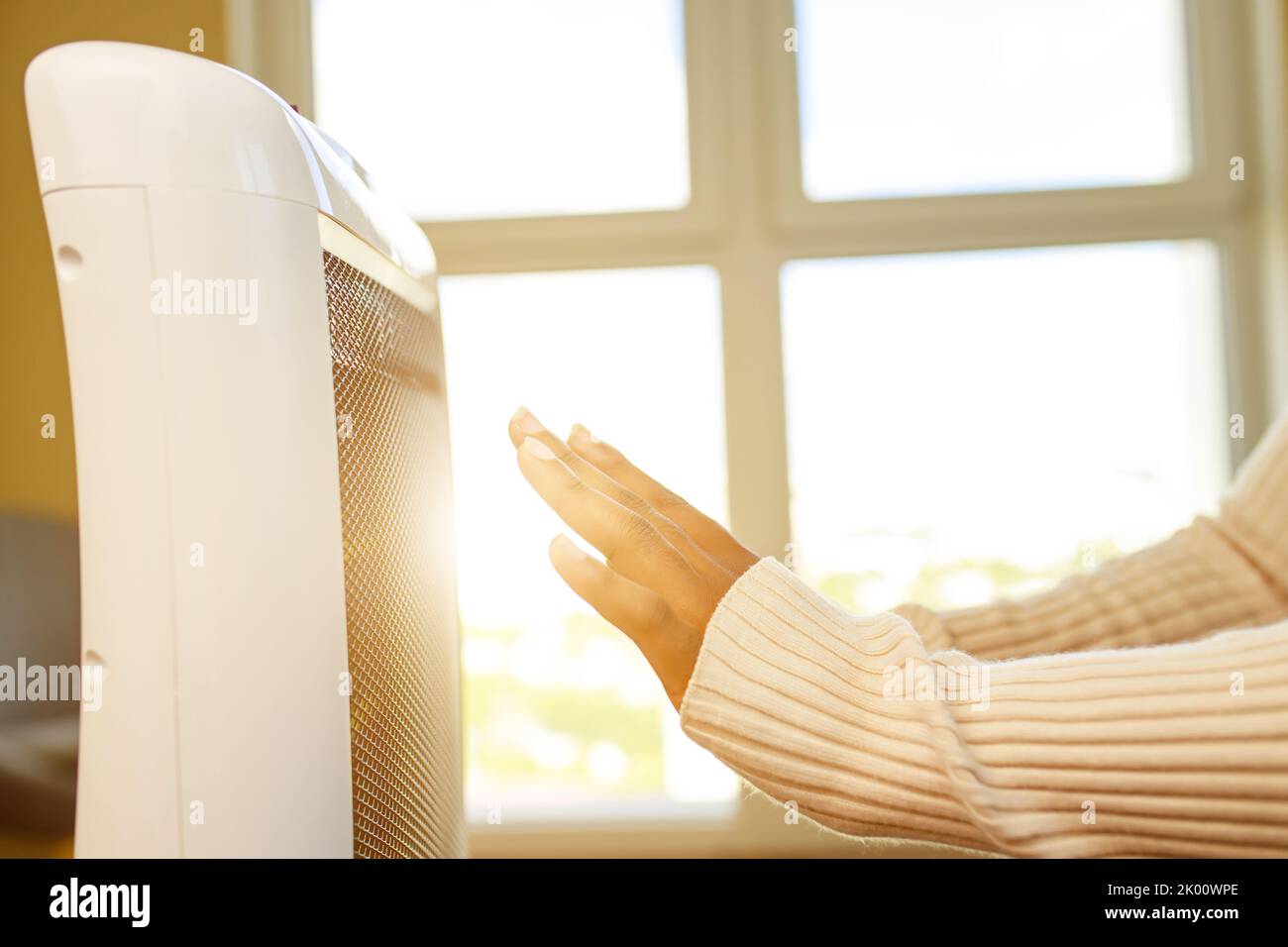 latin american woman warming her hands in cold room with heater Stock ...