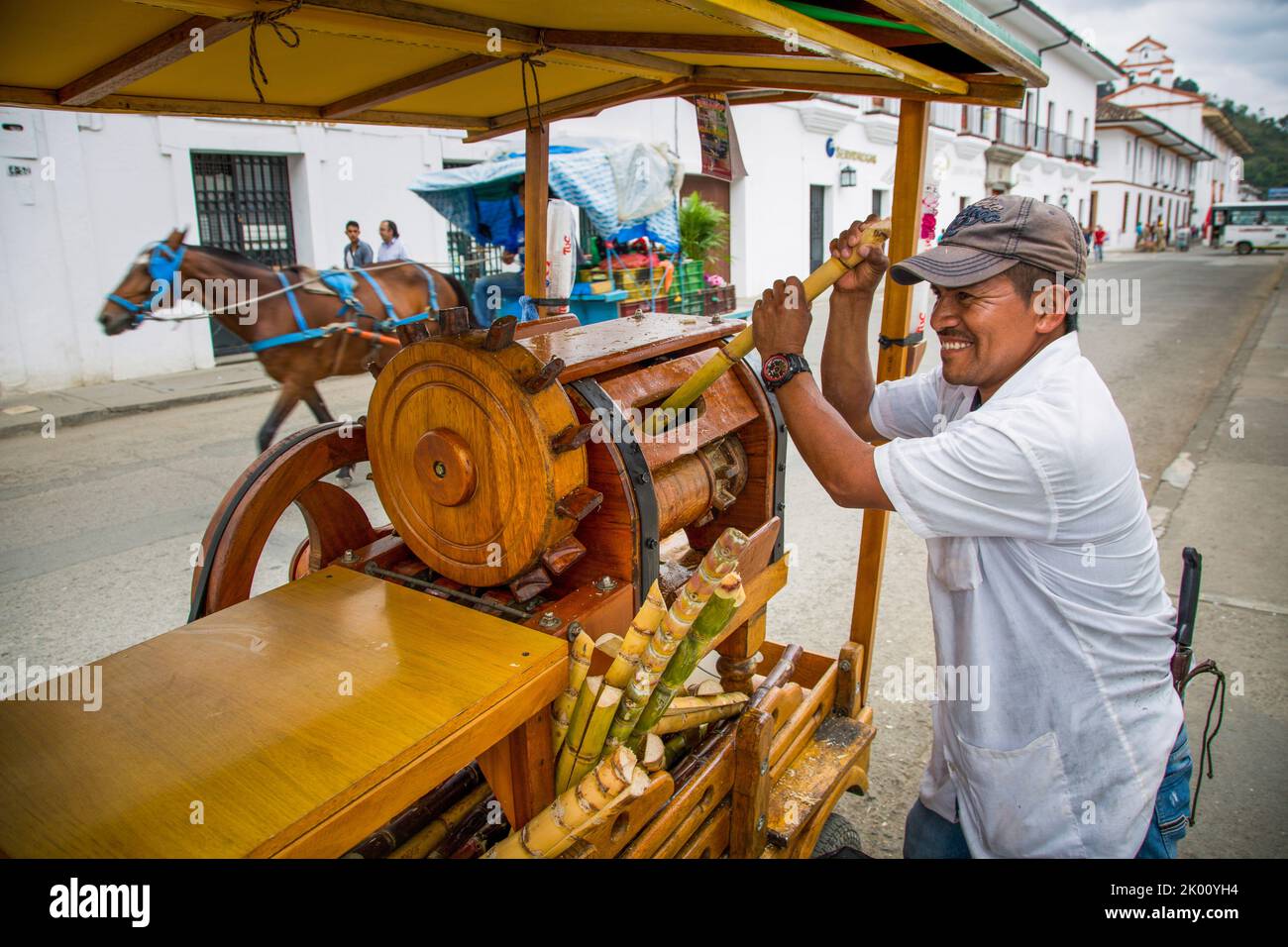 Colombia, Papayan, a sugar can juice seller on the street is pressing ...