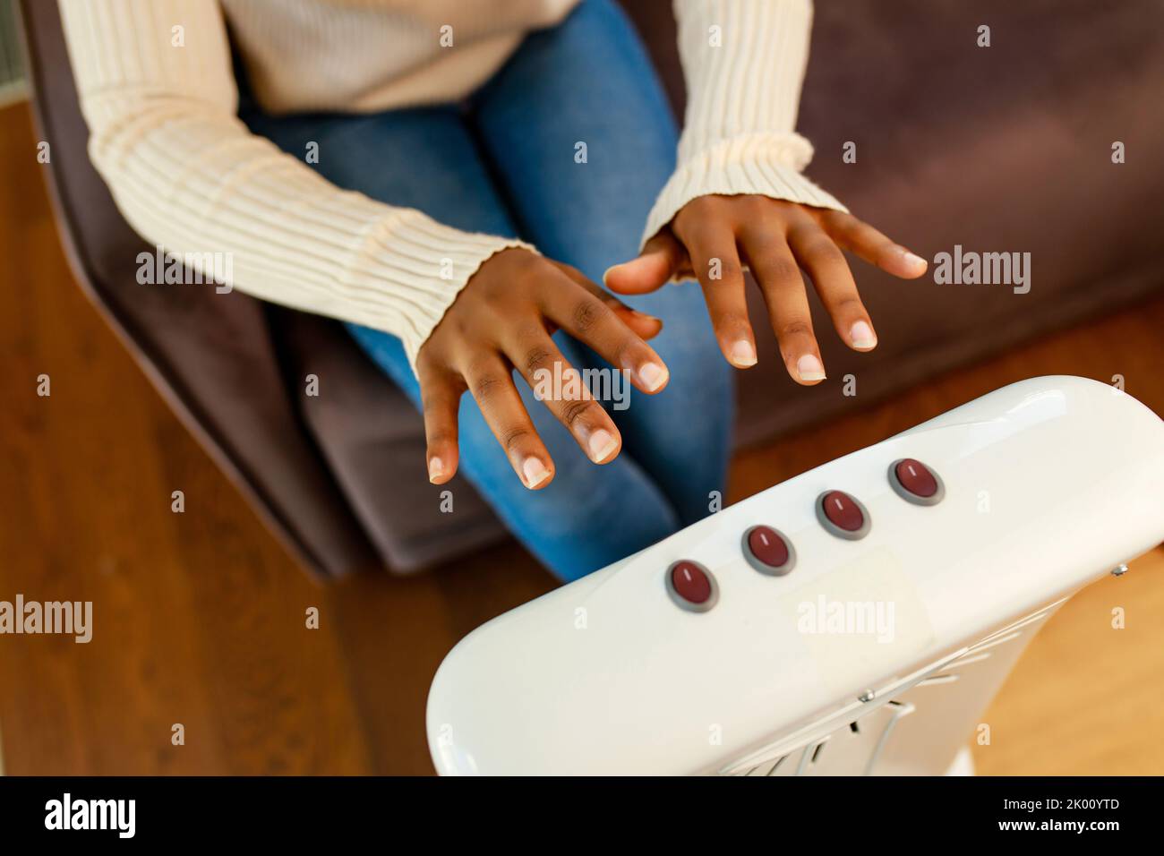 latin american woman warming her hands in cold room with heater Stock ...