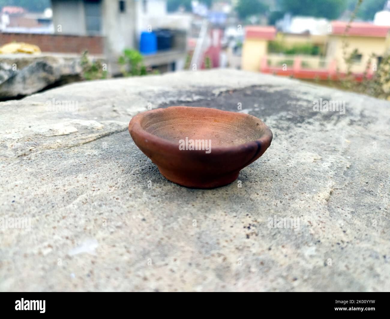 oil clay lamp put on a big stone Stock Photo - Alamy