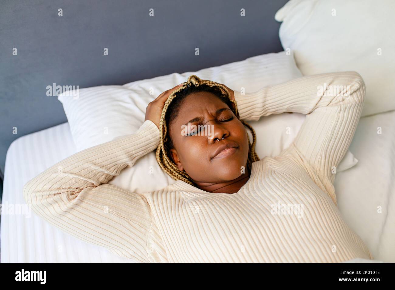 african american woman trying to sleep but headache makes it difficult ...