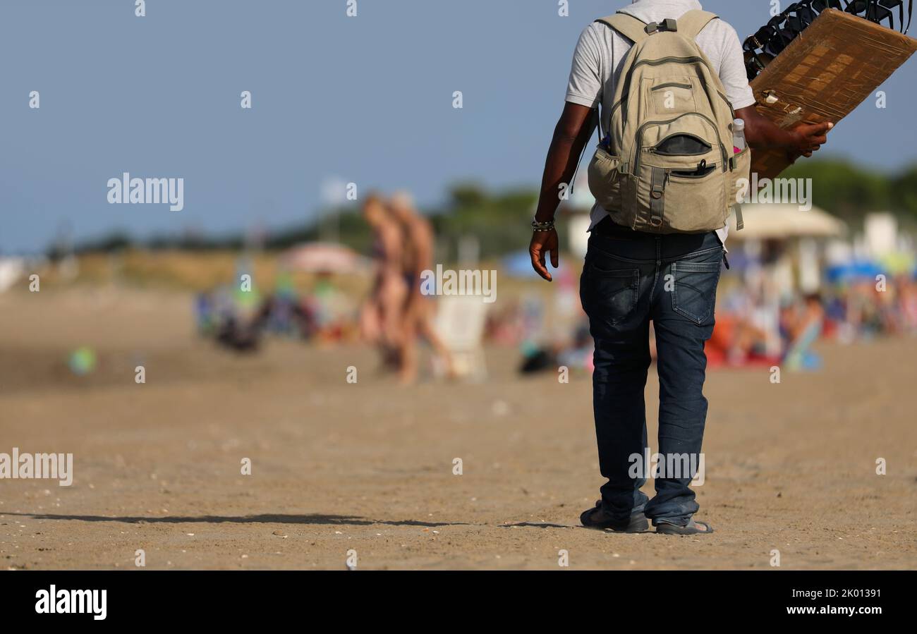 poor immigrant who is a peddler on the beach in the summer Stock Photo ...