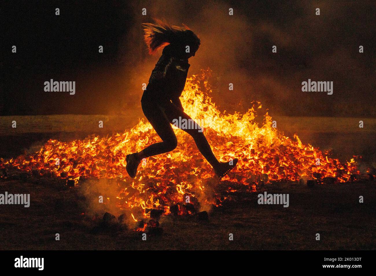 Summer solstice celebration jumping into the fire. Burning flames ...