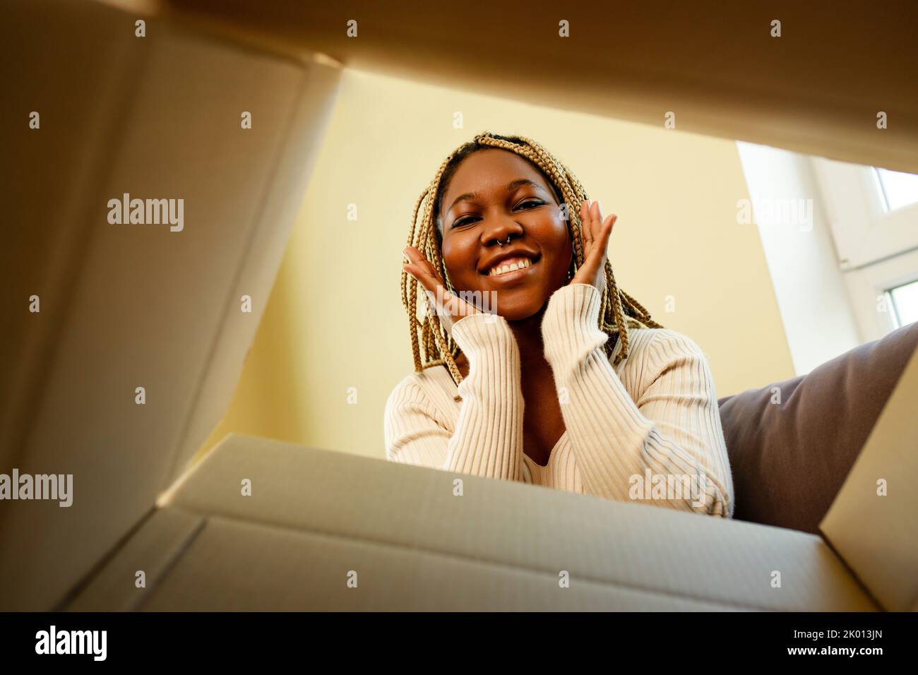 happy african american woman looking inside of box and surprised of ...