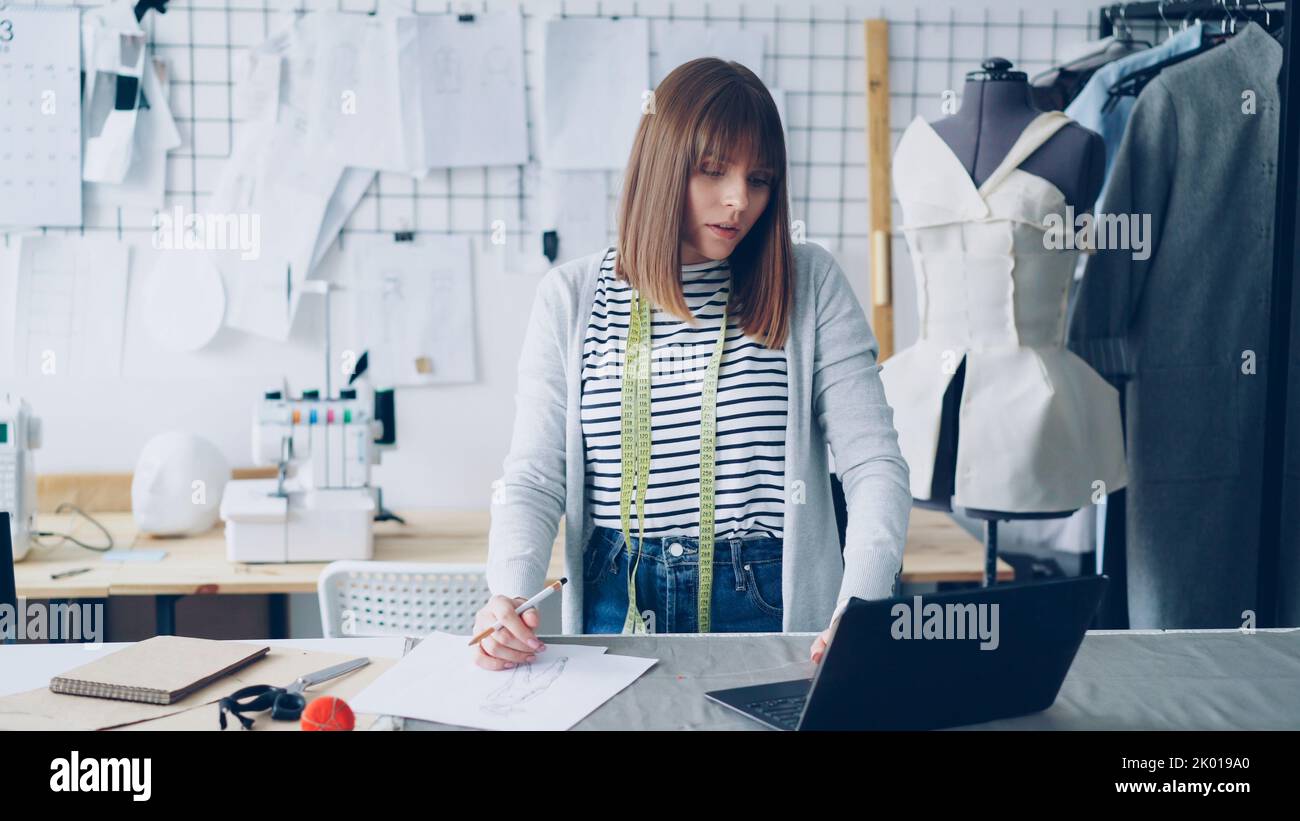 Beautiful fashion designer is drawing clothing sketches for her new ...