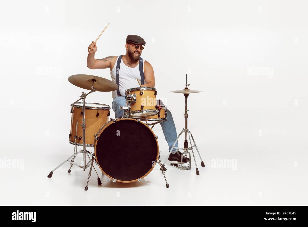 Portrait of emotive, expressive man in sunglasses playing drums ...