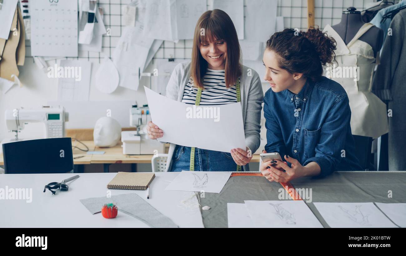 Attractive young women working in design industry are comparing ...