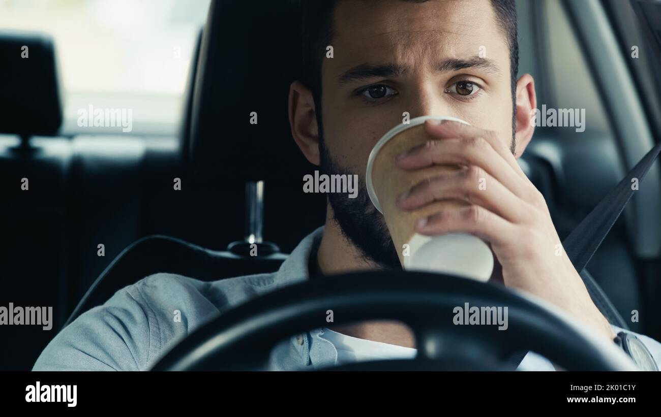 young man driving car and drinking coffee from paper cup,stock image ...