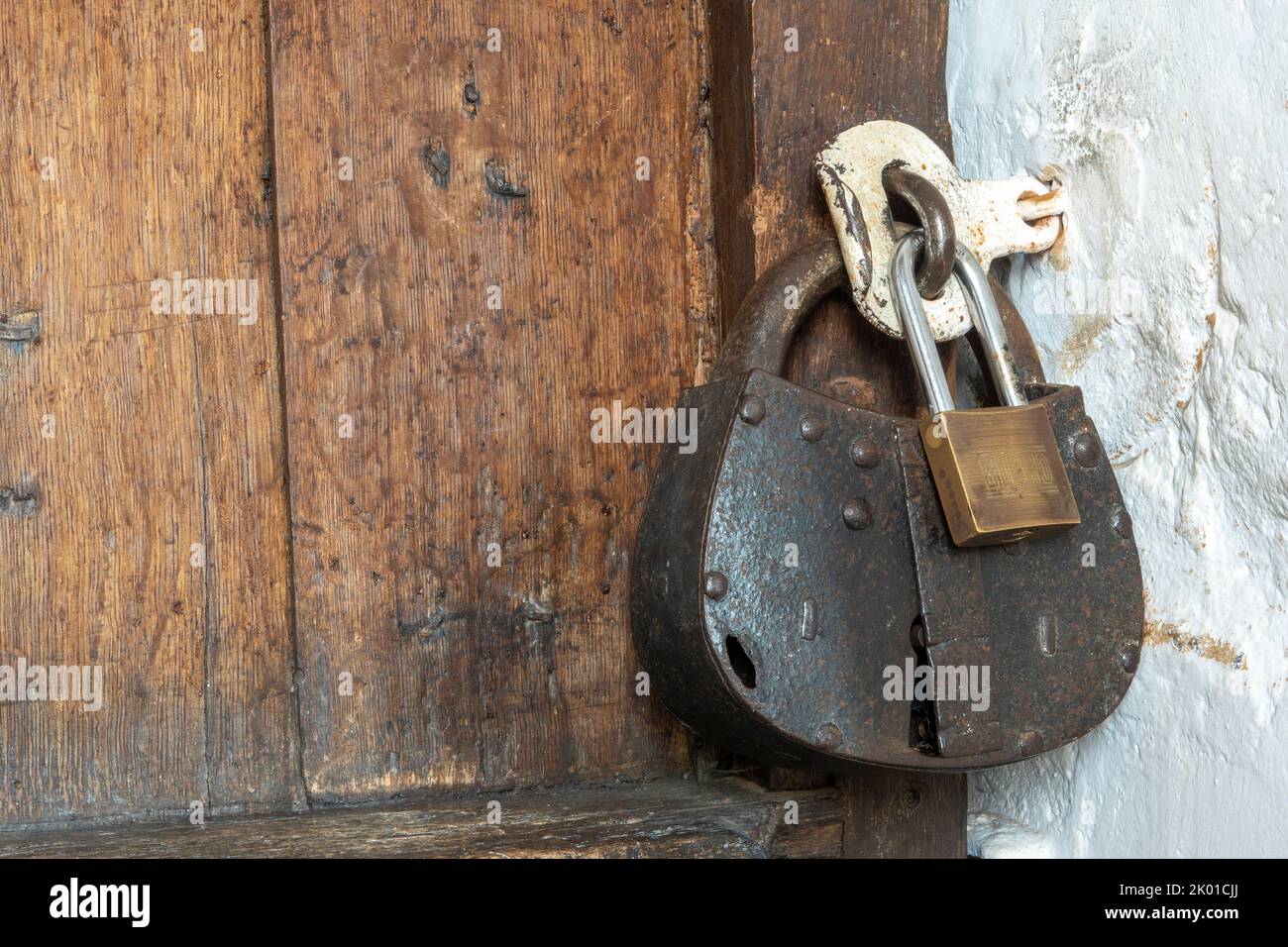 A very large iron antique padlock and a small modern brass padlock ...