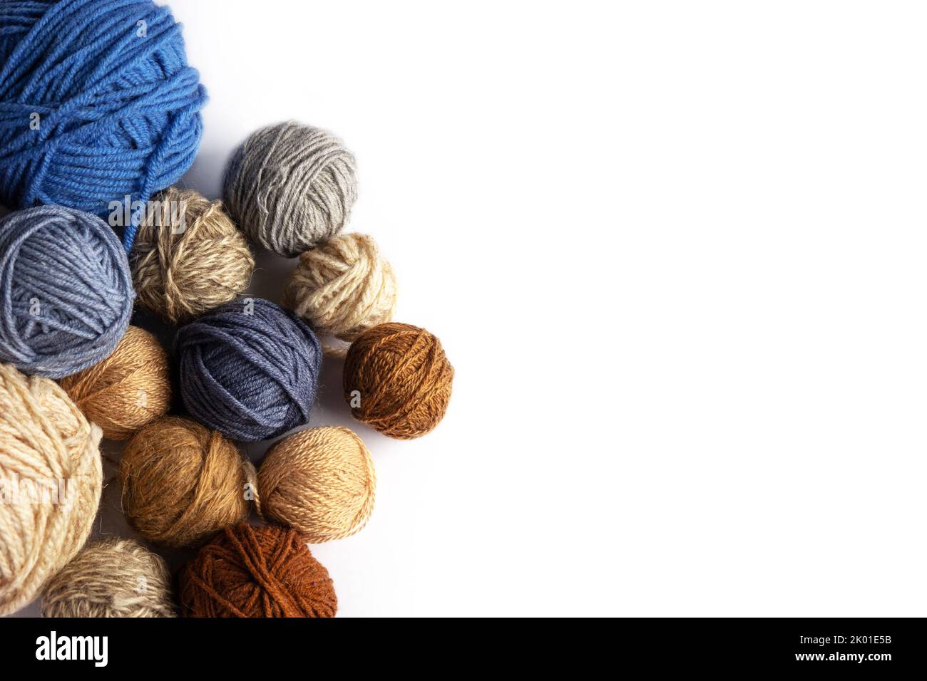 Blue, gray and brown balls of knitting thread on a white background for ...