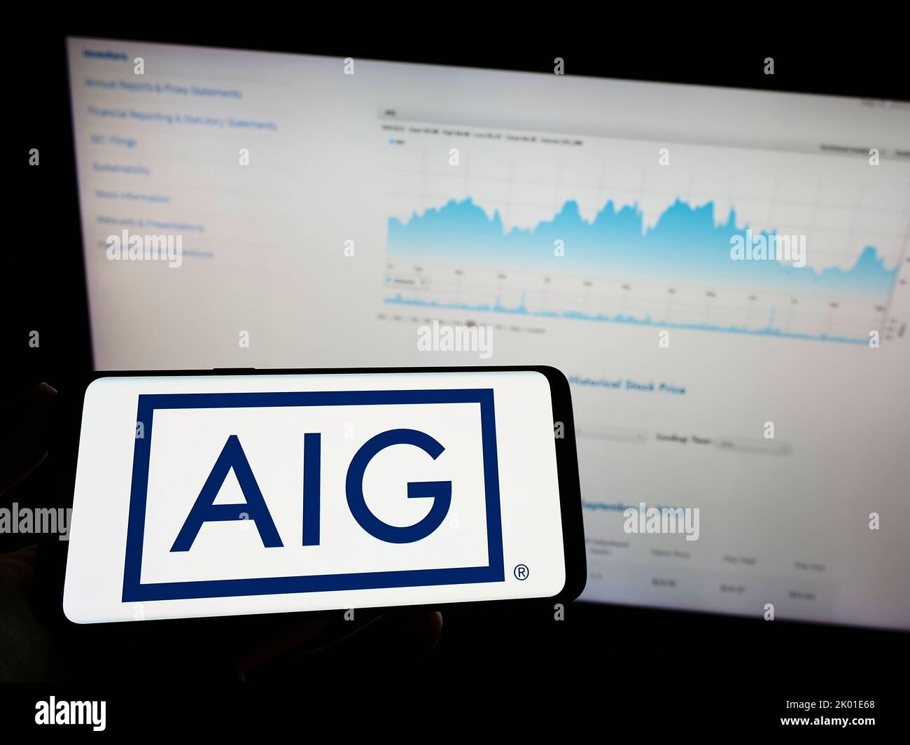 Person holding mobile phone with logo of company American International Group Inc. (AIG) on ...