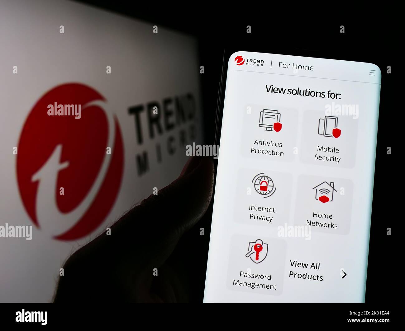 Person holding smartphone with webpage of cybersecurity company Trend Micro Inc. on screen in ...