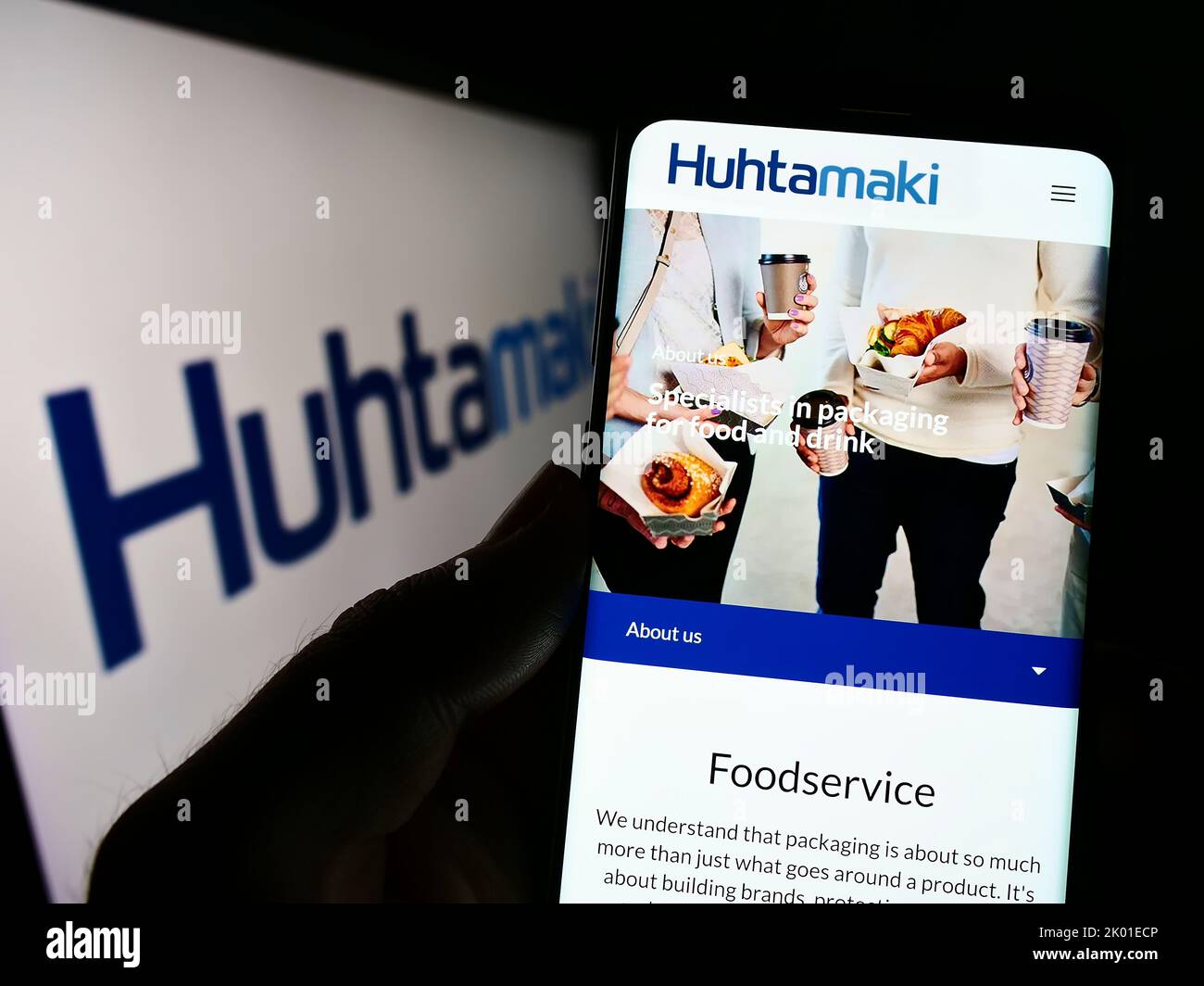 Person holding smartphone with website of Finnish packaging company ...