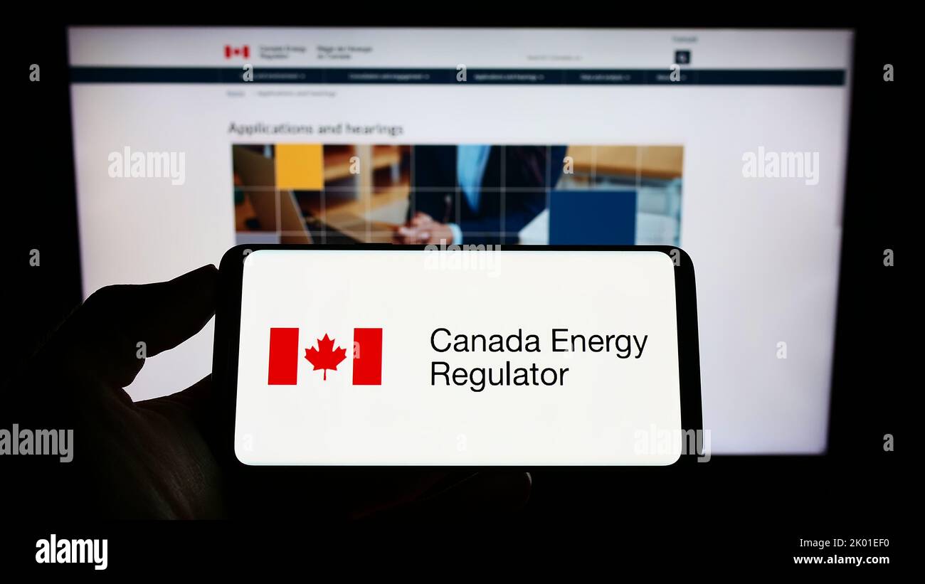 Person holding mobile phone with logo of Canadian agency Canada Energy ...