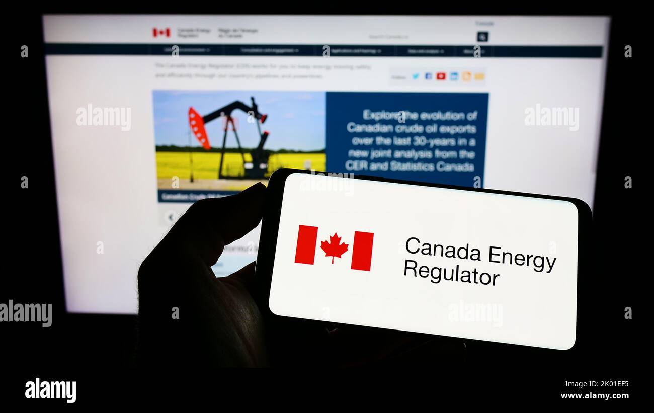 Person holding cellphone with logo of Canadian agency Canada Energy ...