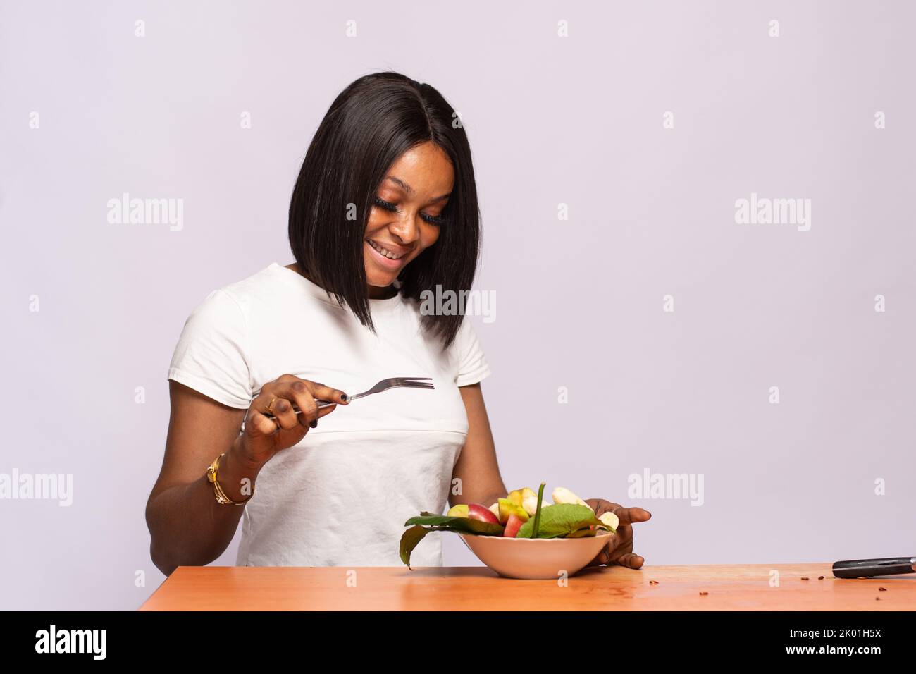 beautiful african woman eating a bowl of fruits Stock Photo - Alamy