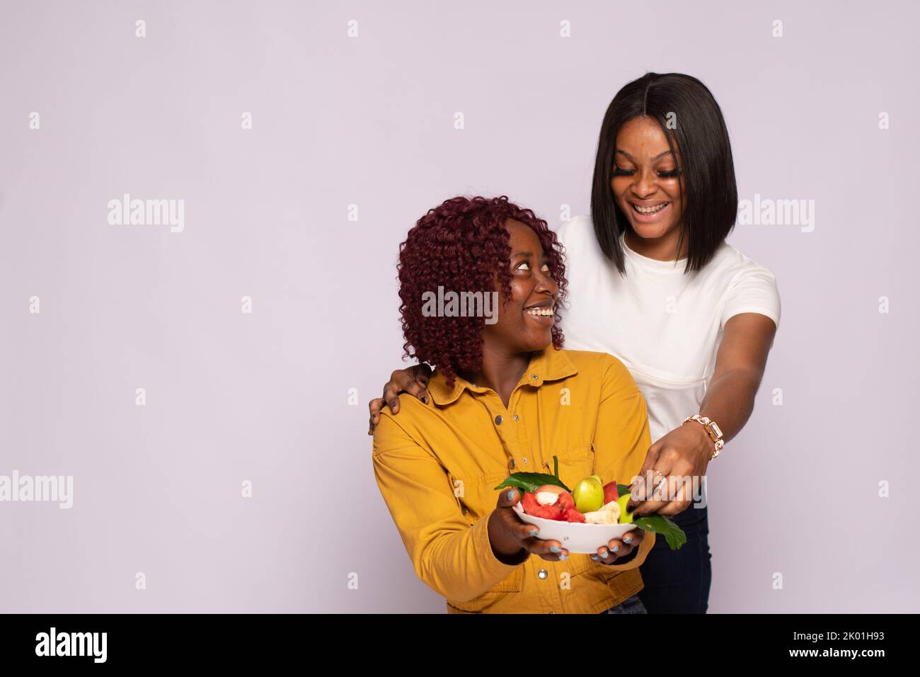 two african ladies sharing a bowl of fruits Stock Photo - Alamy