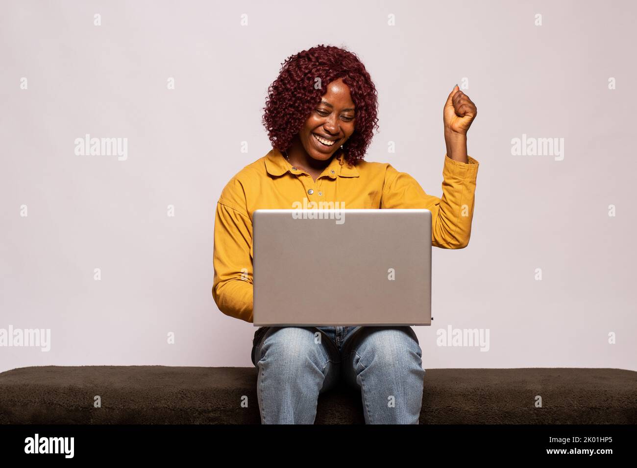 young black lady using her laptop rejoices Stock Photo - Alamy