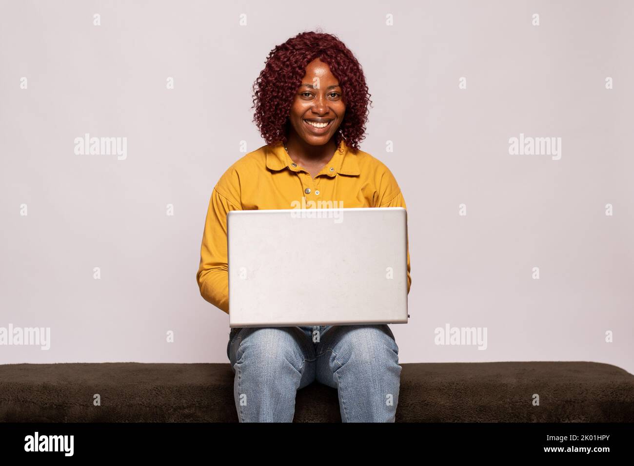young black lady using her laptop smiling Stock Photo - Alamy