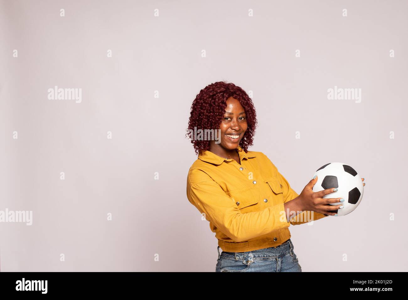 excited young black lady playing with a football Stock Photo - Alamy
