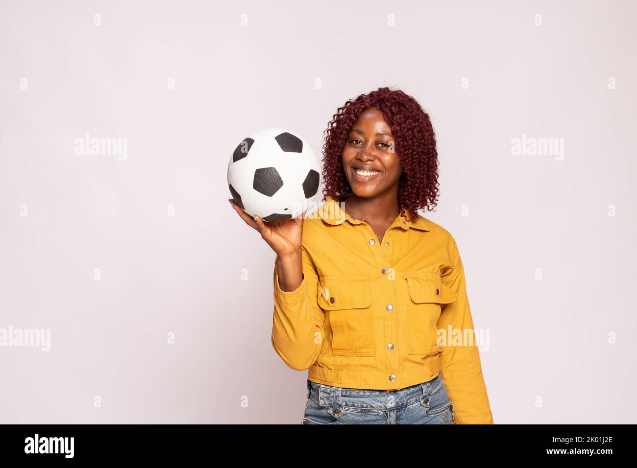black lady holding a football smiling Stock Photo - Alamy