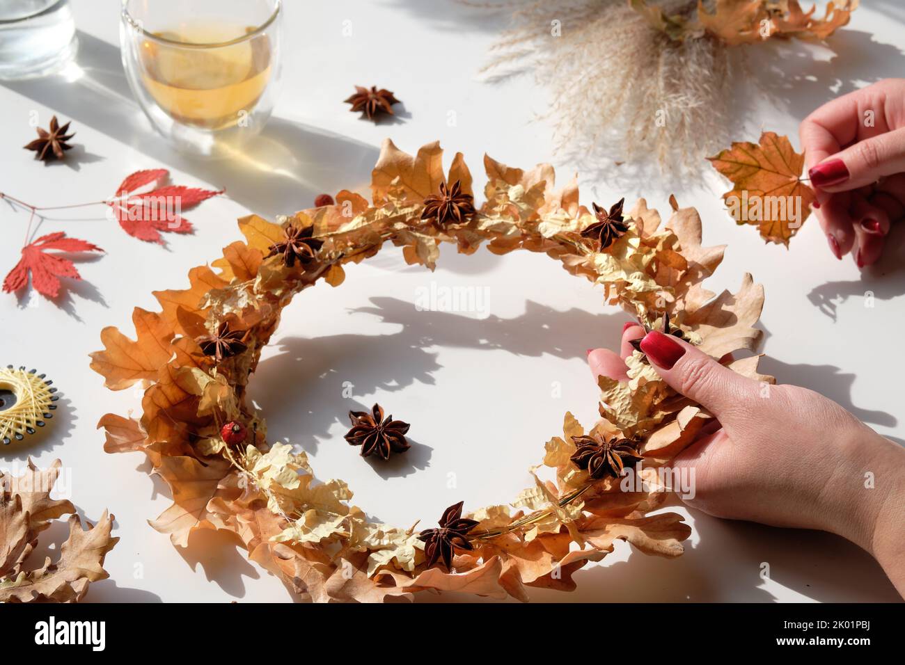 Hands making dried floral wreath from dry Autumn leaves and Fall ...