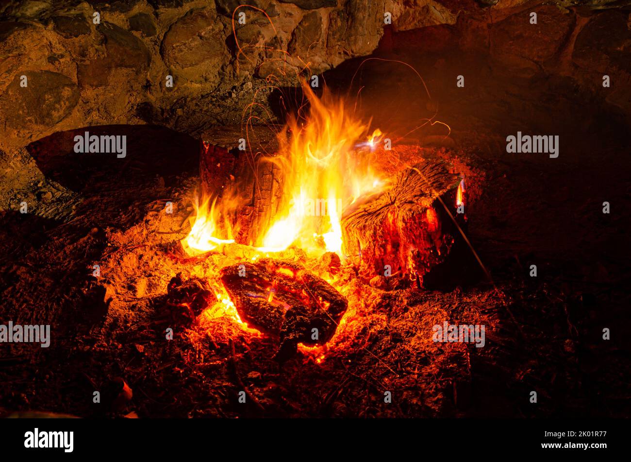 Logs burning in a campfire in a fire pit Stock Photo - Alamy