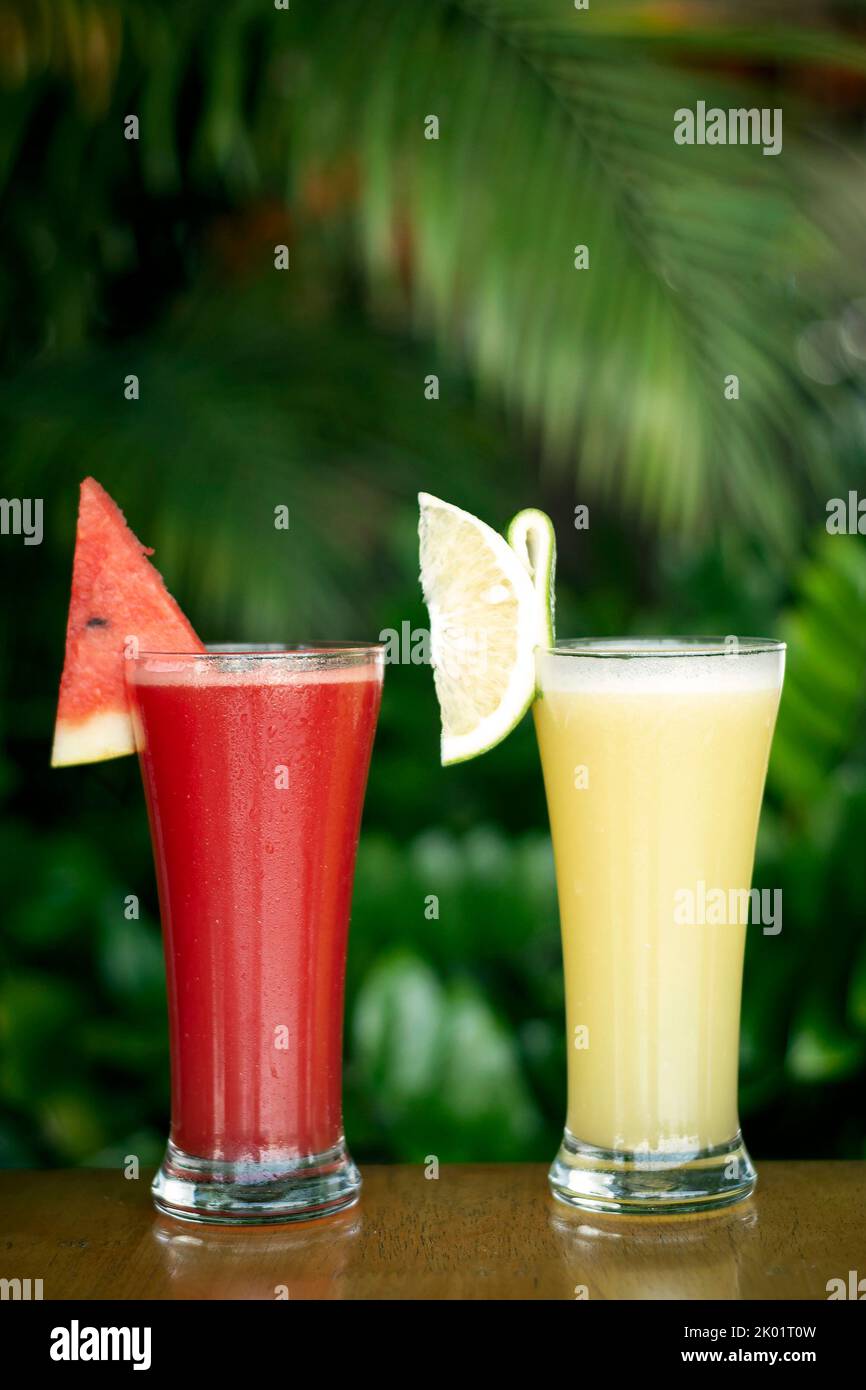 mixed organic fresh fruit juice glasses in cafe with.garden background ...