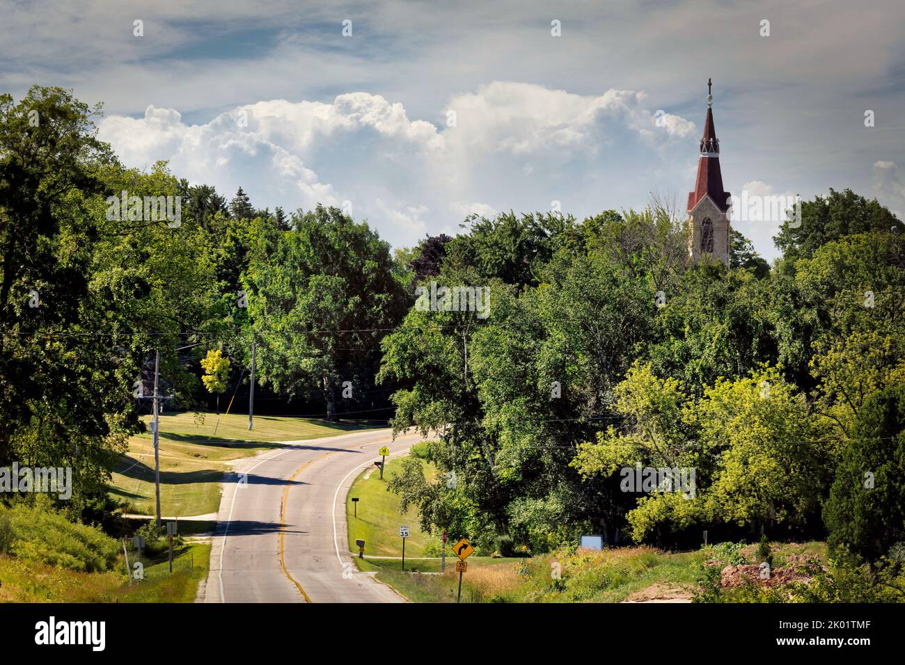 A winding road leads to a church that stands in the countryside near ...