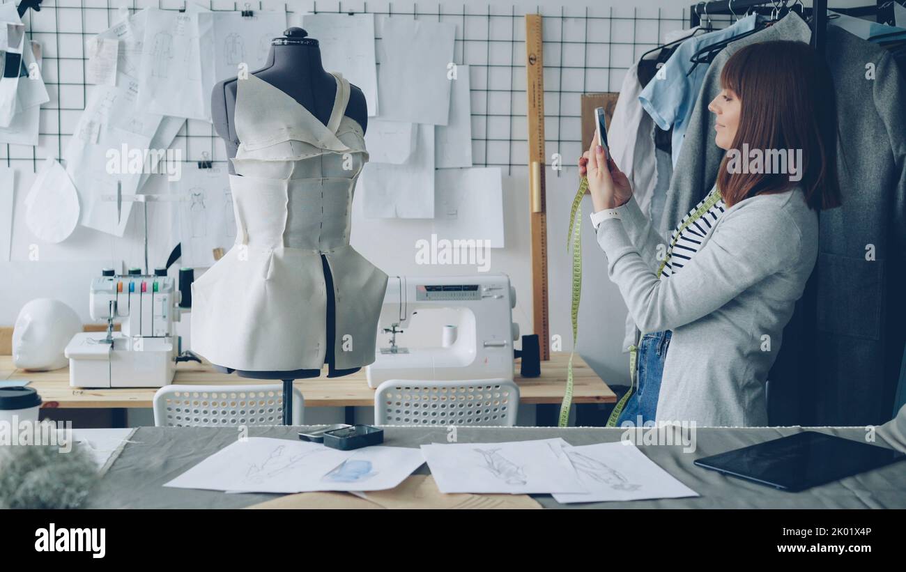 Self-employed female tailor taking photos of it with smartphone. Nice ...