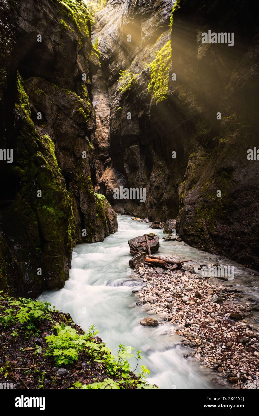 The sun shining down into Partnach Gorge illuminating the rocks and ...